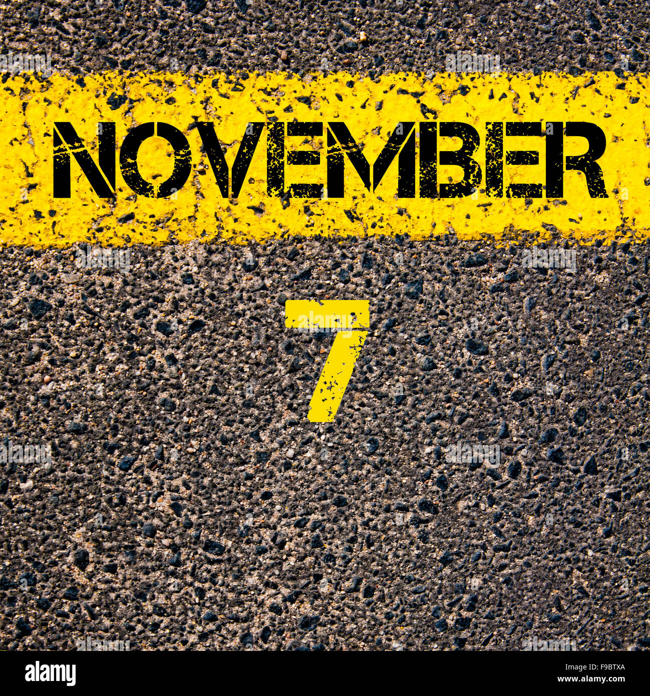 7 November calendar day written over road marking yellow paint line ...