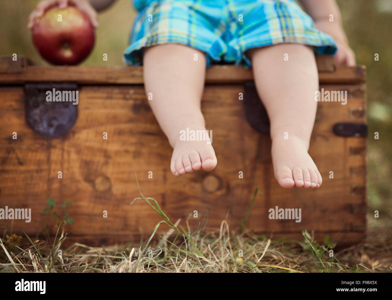 Cute kid holding a red apple in green park Stock Photo - Alamy