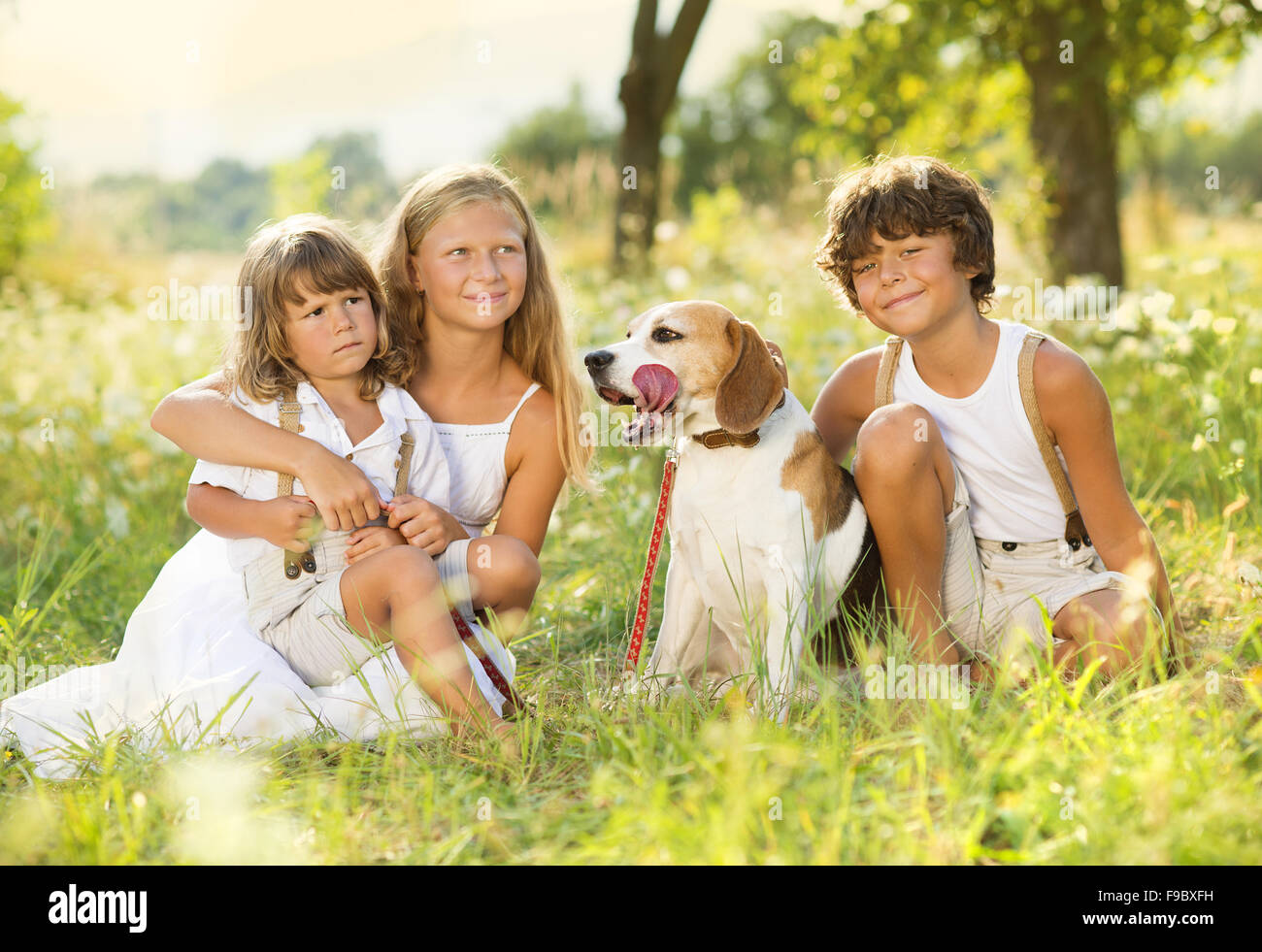 Cute kids spending time outside with their dog Stock Photo - Alamy