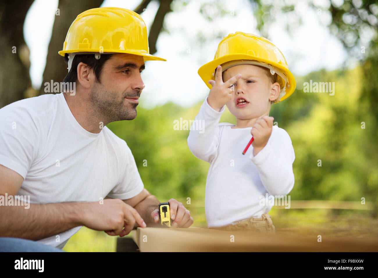 Little son helping his father with building work Stock Photo - Alamy