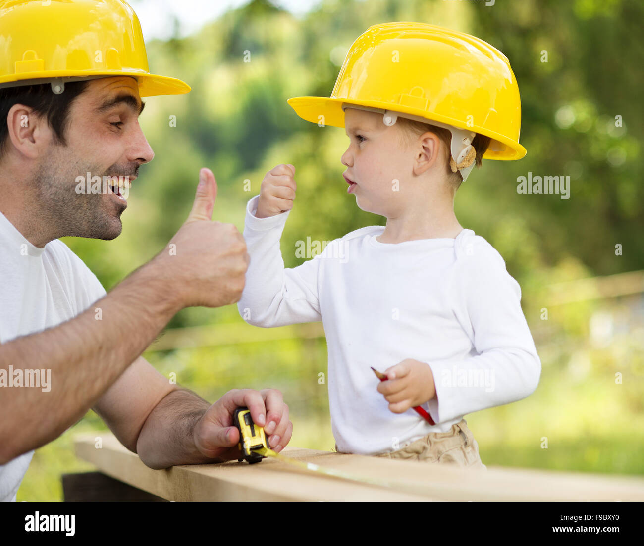 Little son helping his father with building work Stock Photo - Alamy