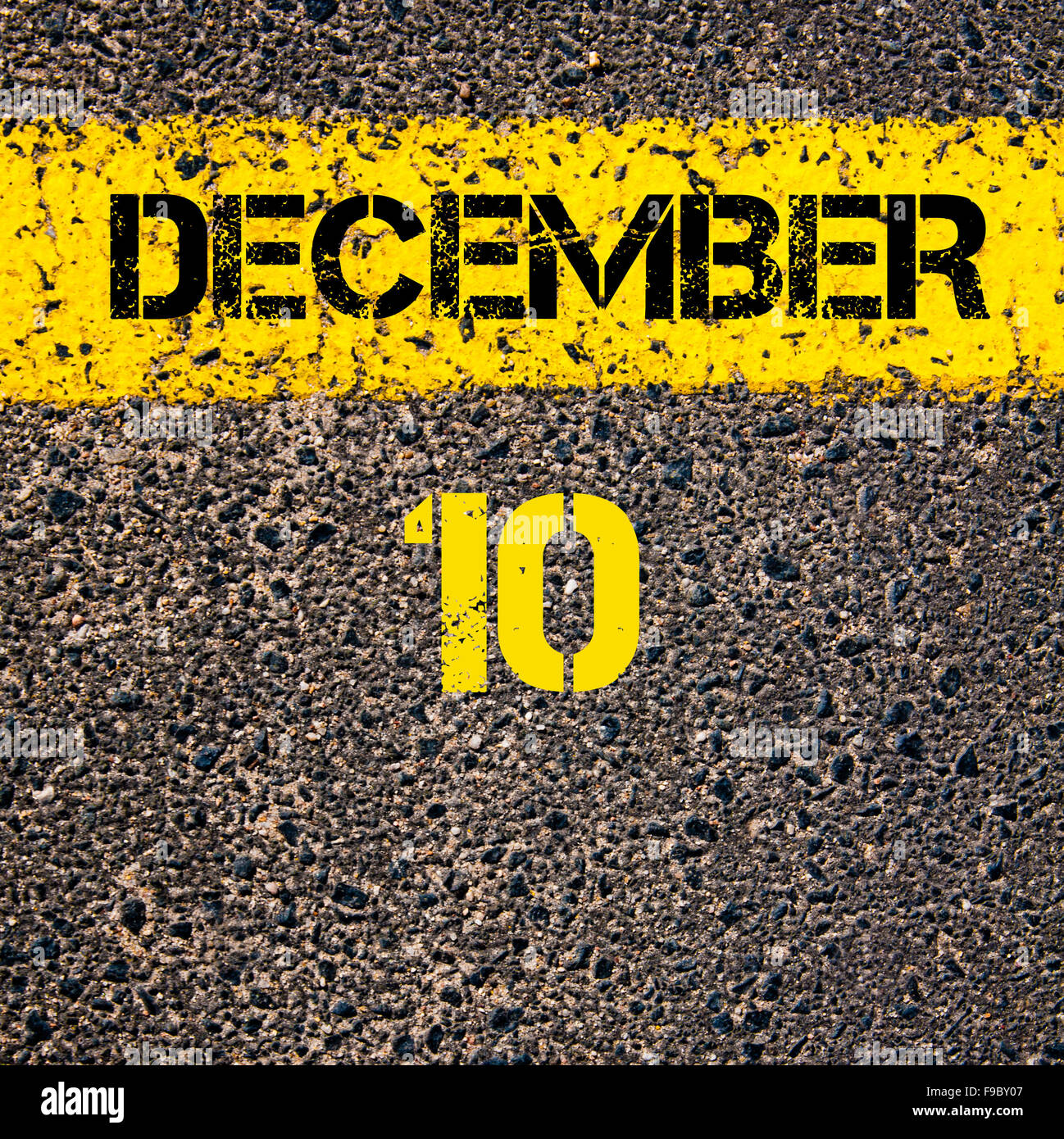 10 December calendar day written over road marking yellow paint line ...