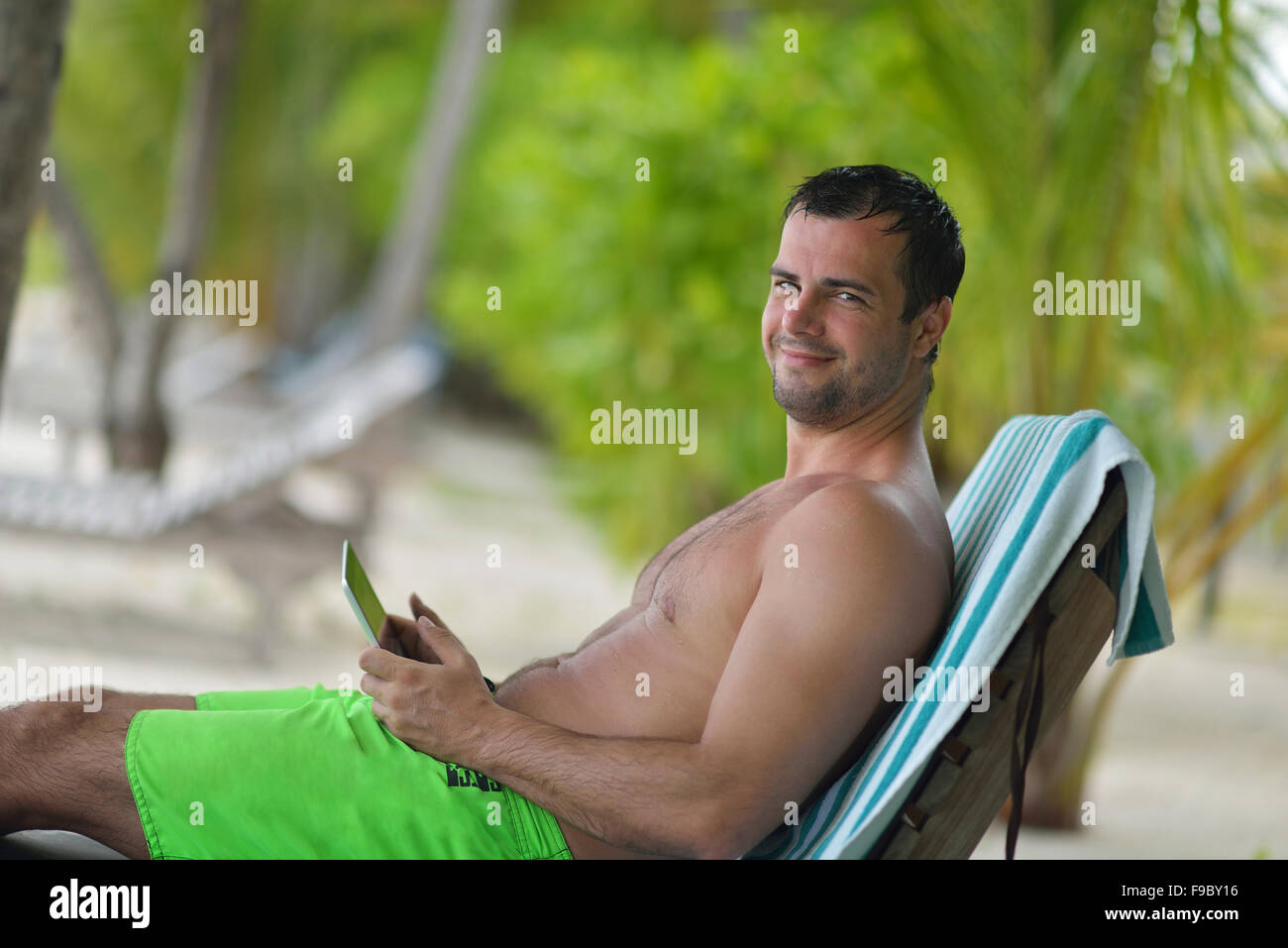 business man relaxing and use tablet computer at beautiful tropical ...