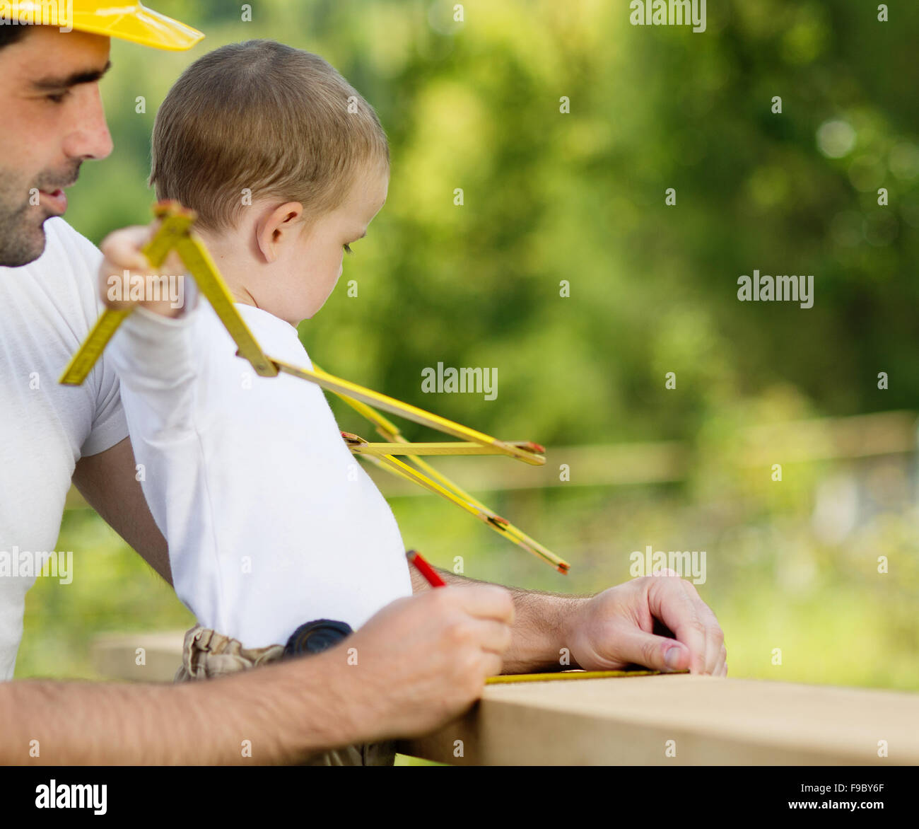 Little son helping his father with building work Stock Photo - Alamy