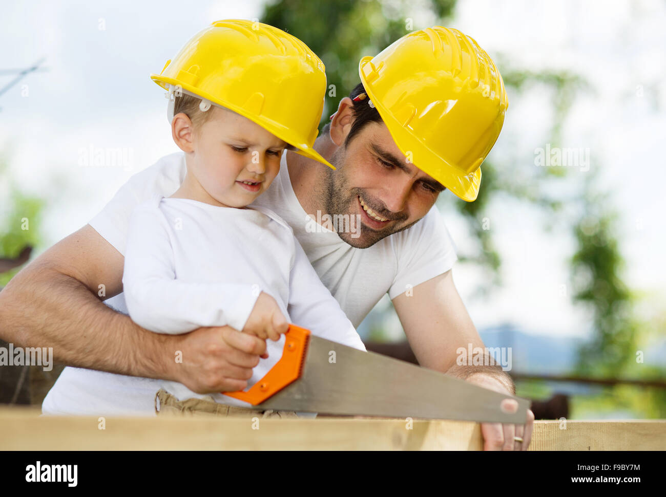 Little son helping his father with building work Stock Photo - Alamy
