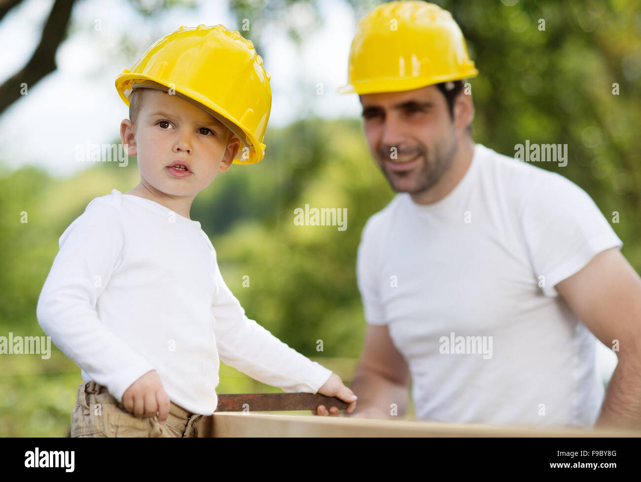 Little son helping his father with building work Stock Photo - Alamy