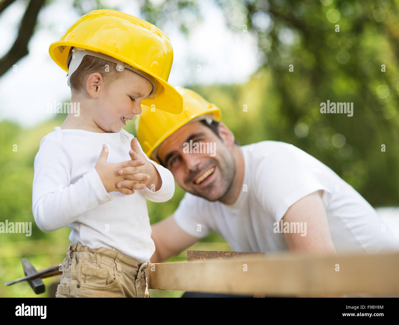 Little son helping his father with building work Stock Photo - Alamy