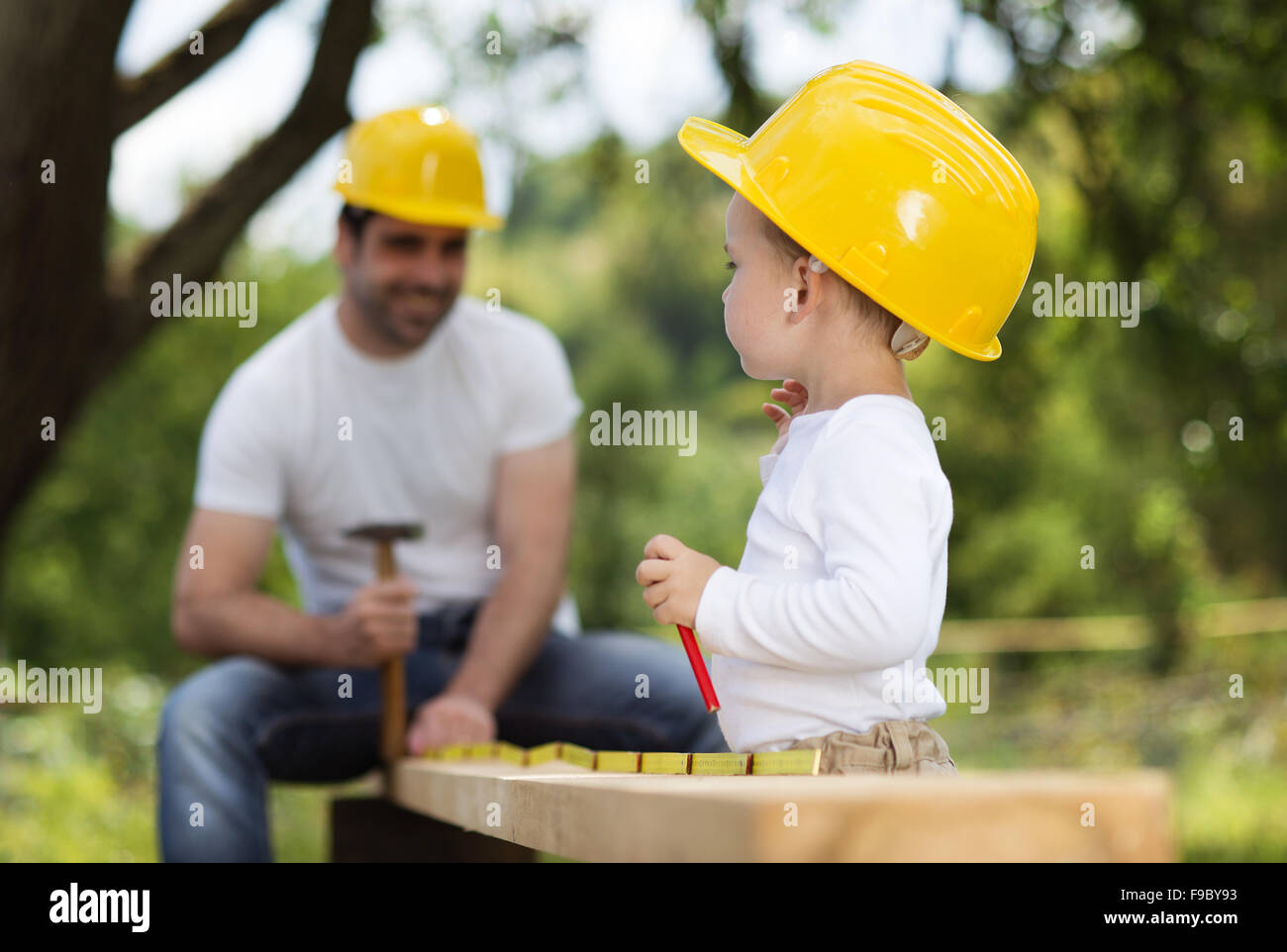 Little son helping his father with building work Stock Photo - Alamy
