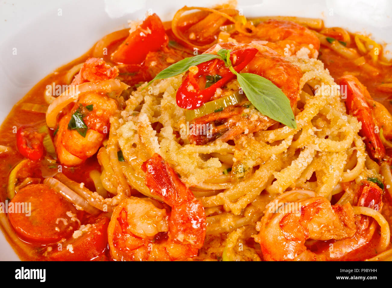 A plate of linguini with sauteed shrimp, tomato, chili and olive oil ...