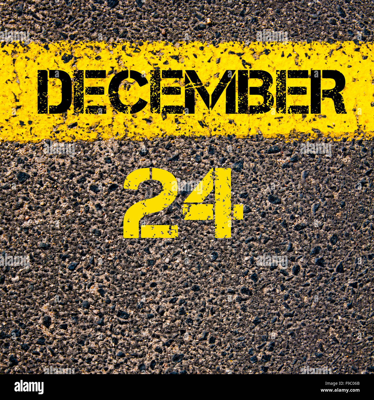 24 December calendar day written over road marking yellow paint line ...
