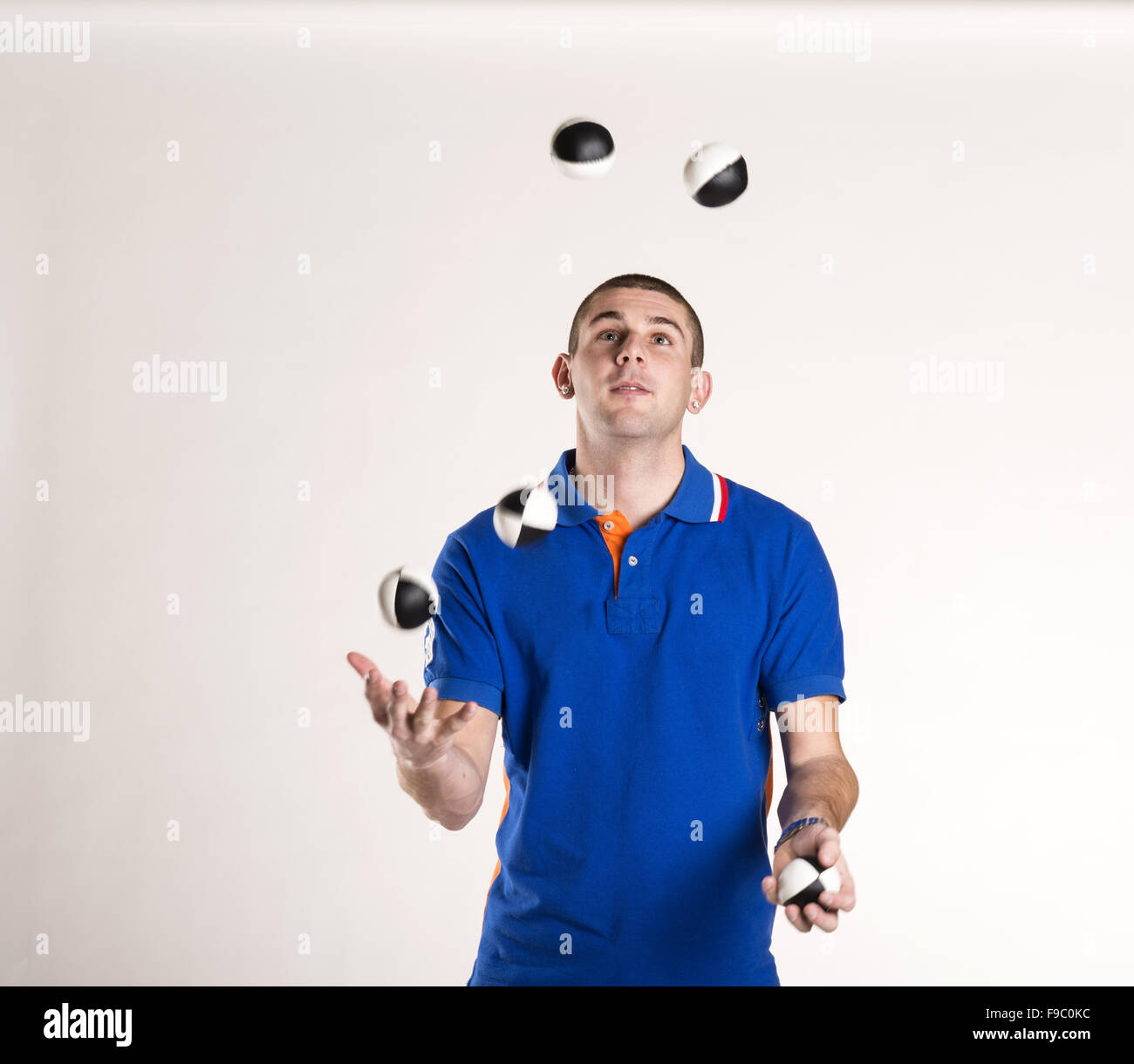 Young man juggling with several balls at once Stock Photo - Alamy