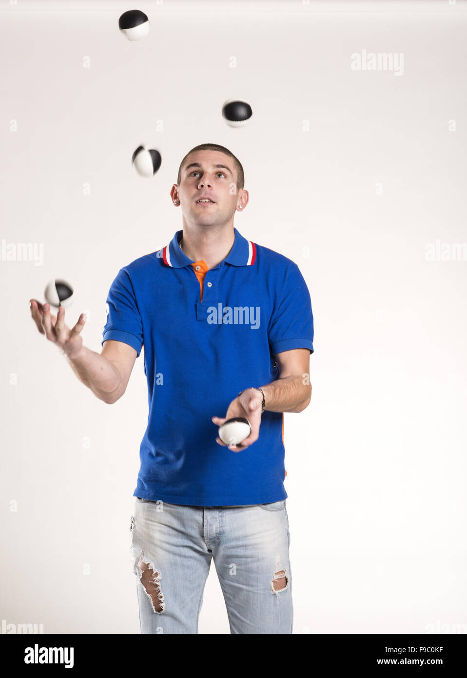 Young man juggling with several balls at once Stock Photo - Alamy
