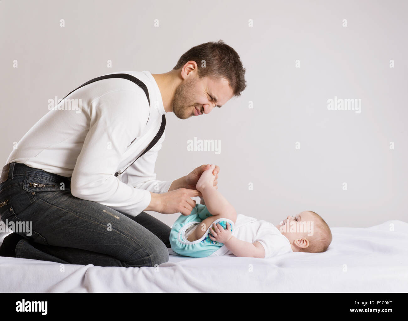 Young attractive father is changing nappy to his baby girl Stock Photo ...