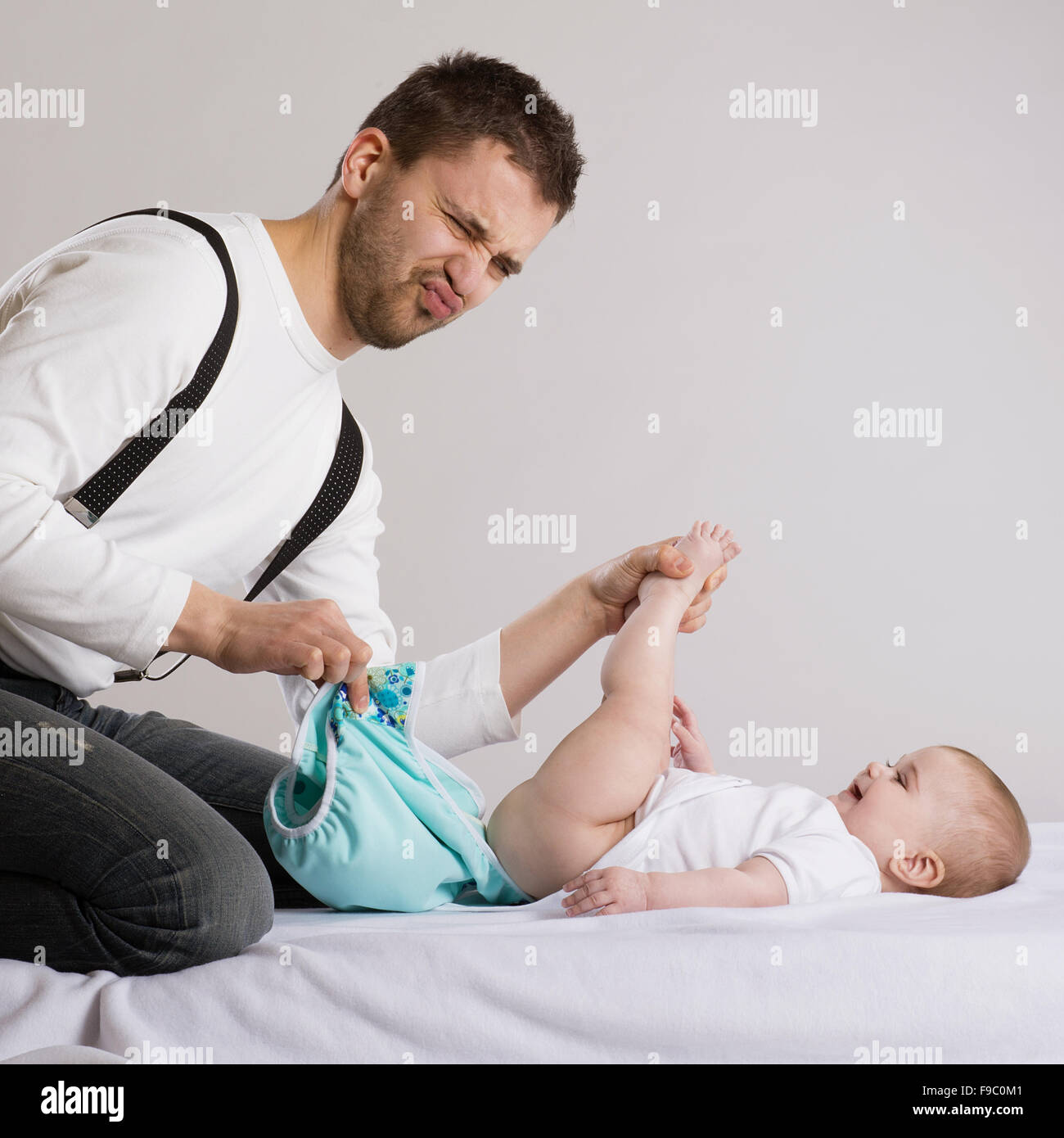 Young attractive father is changing nappy to his baby girl Stock Photo ...