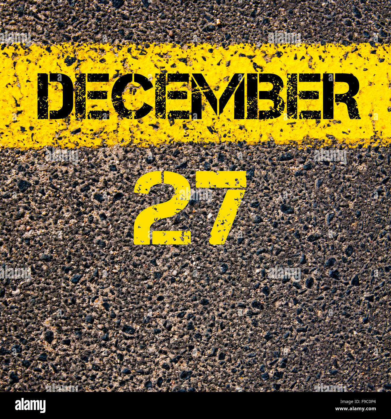27 December calendar day written over road marking yellow paint line ...