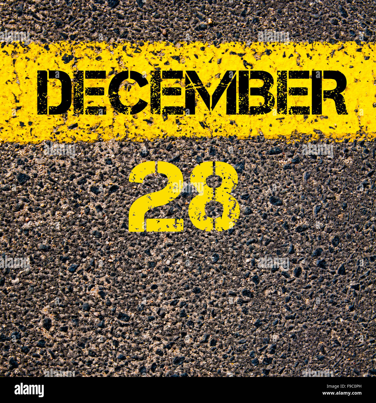 28 December calendar day written over road marking yellow paint line ...