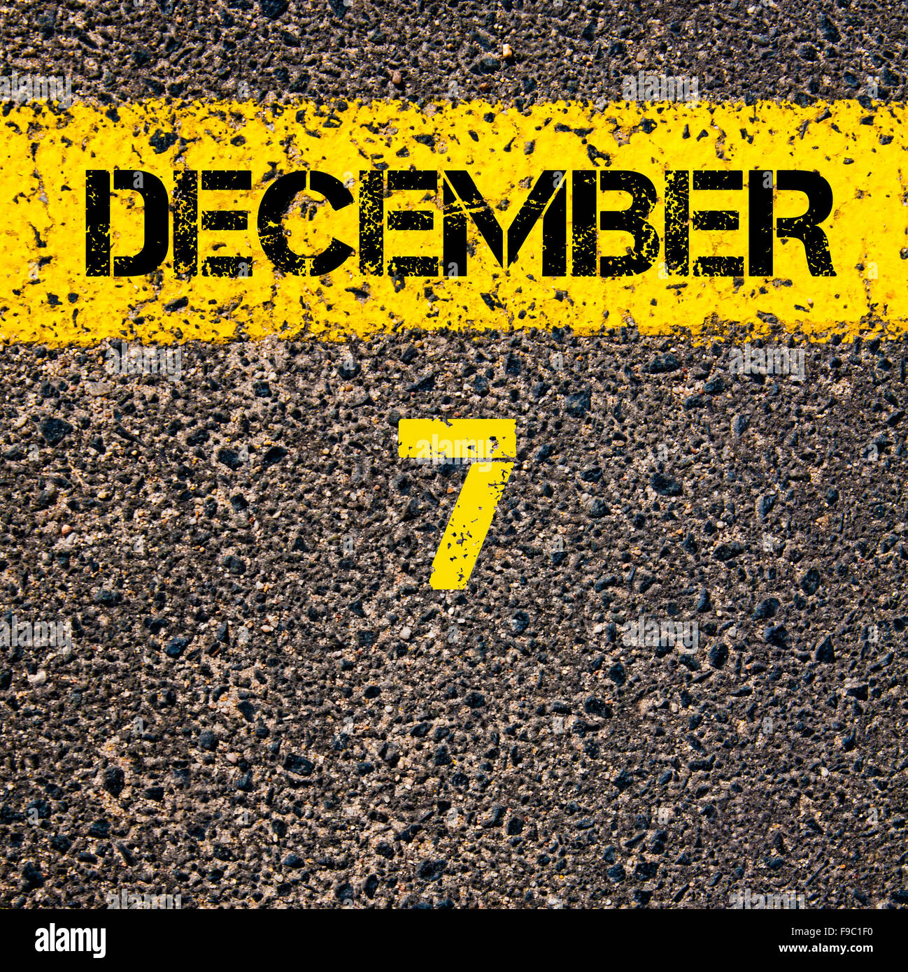 7 December calendar day written over road marking yellow paint line ...
