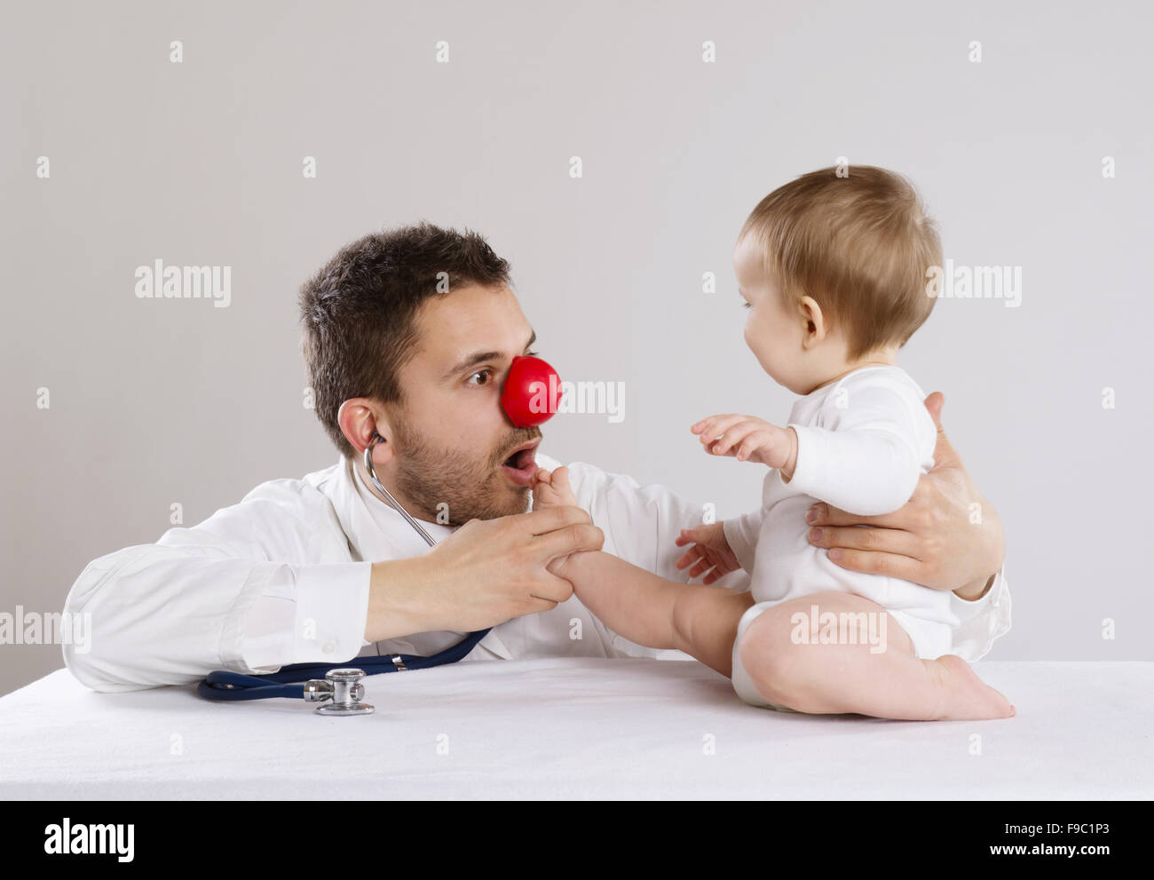 Pediatrician doctor with red nose showing baby stethoscope Stock Photo ...