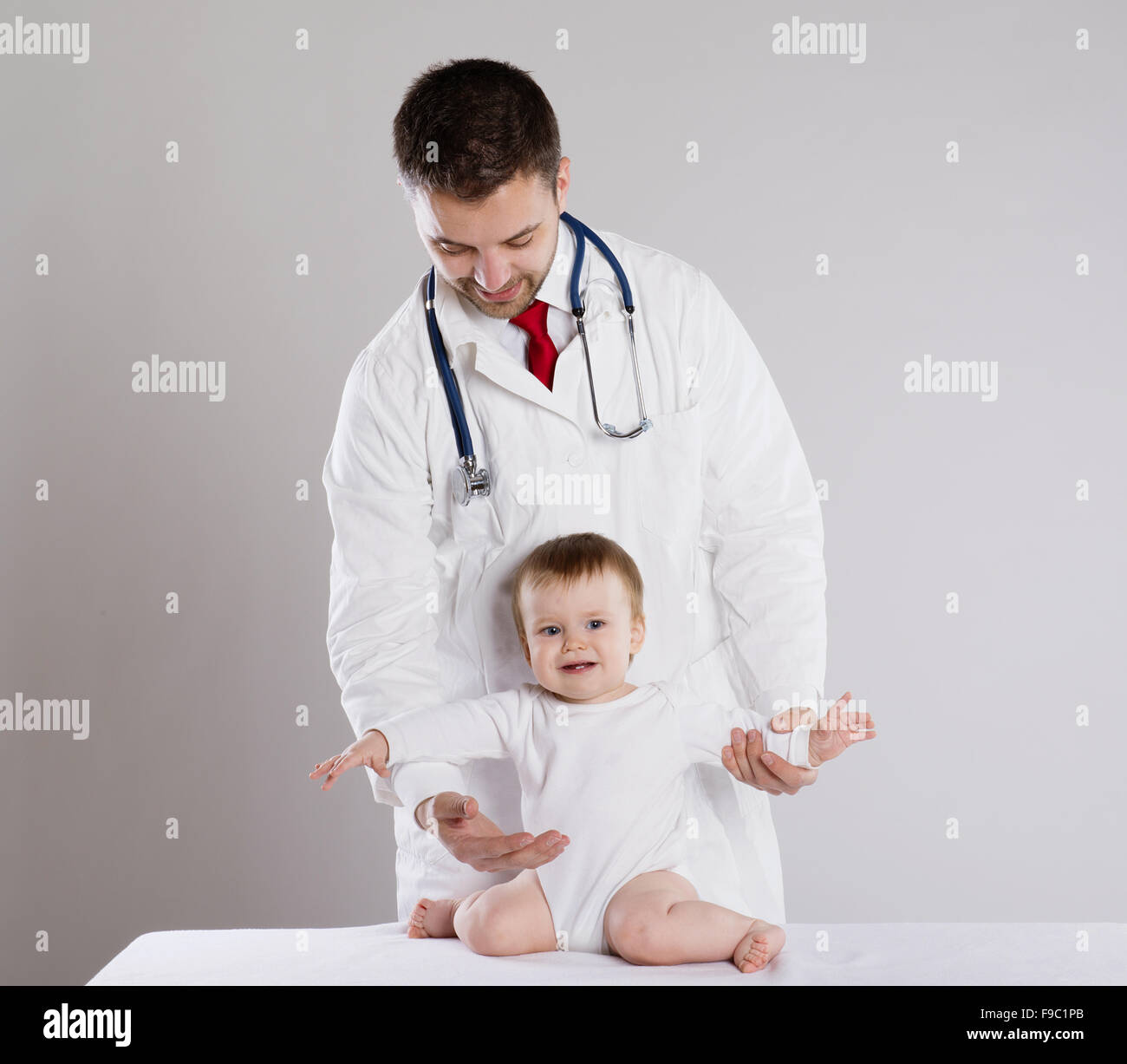 Pediatrician doctor is playing with little baby boy Stock Photo - Alamy
