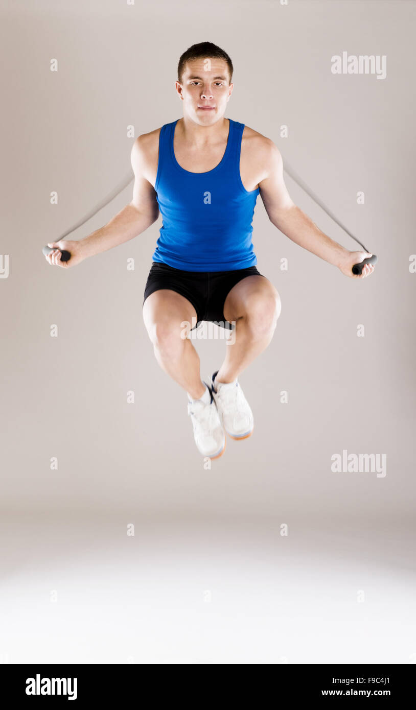 Young active man with rope is training in studio Stock Photo - Alamy