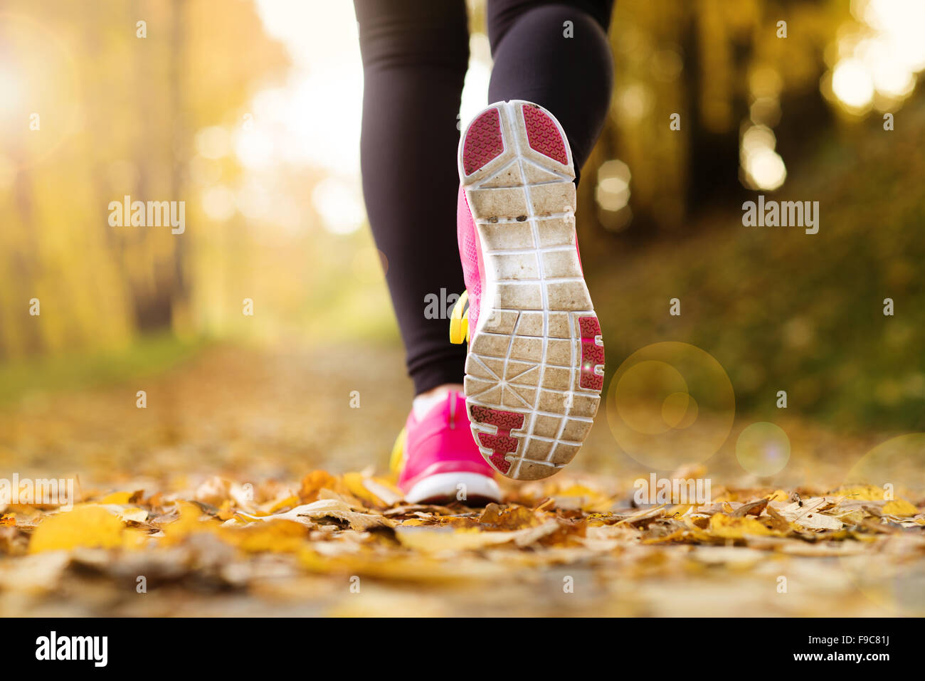Close up of feet of a runner running in autumn leaves training exercise ...