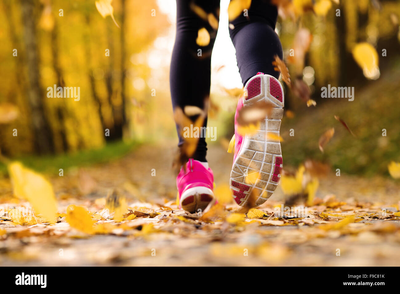 Close up of feet of a runner running in autumn leaves training exercise ...