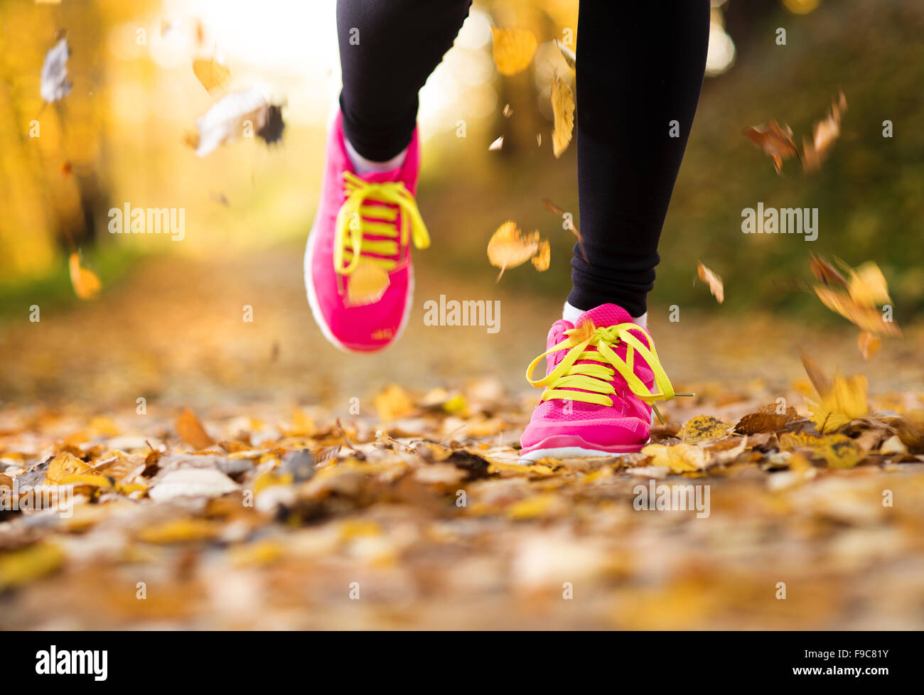 Close up of feet of a runner running in autumn leaves training exercise ...