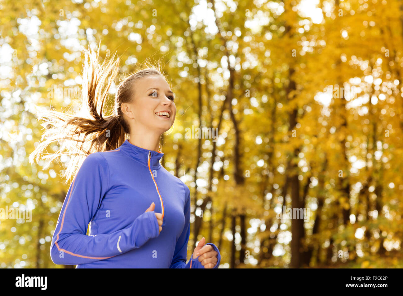 Bautiful running woman jogging in autumn nature Stock Photo - Alamy