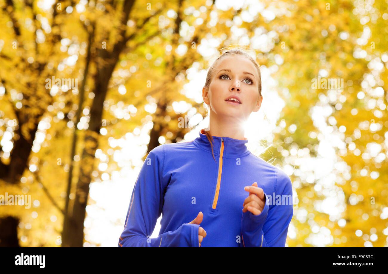 Bautiful running woman jogging in autumn nature Stock Photo - Alamy