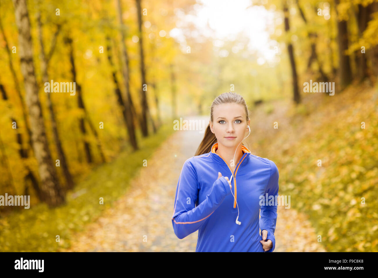 Bautiful running woman jogging in autumn nature Stock Photo - Alamy