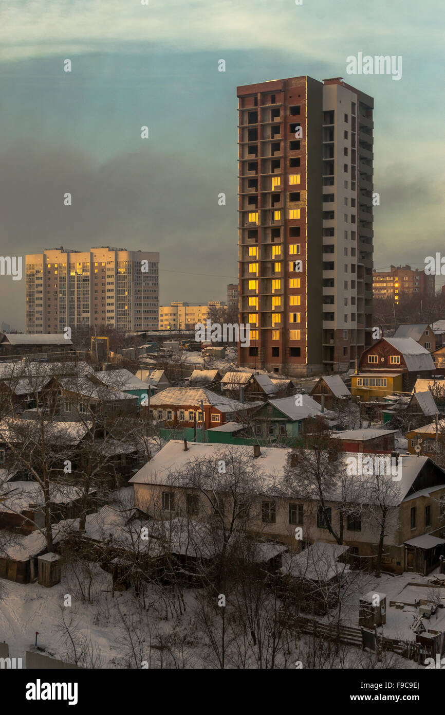 Snow covered cityscape scene with a high rise apartment building and ...