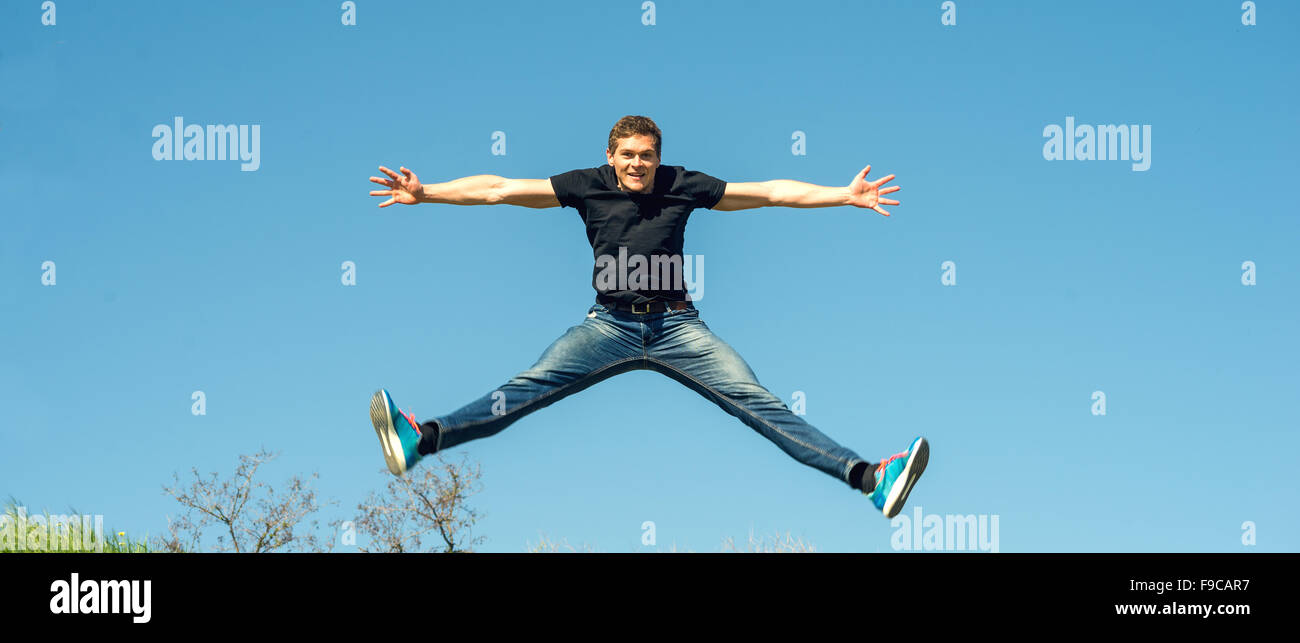 Happy young man jumping Stock Photo - Alamy
