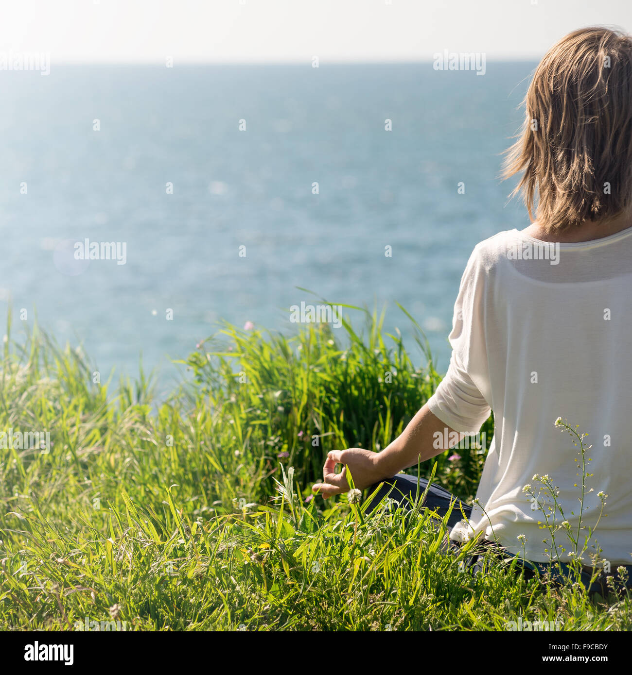 Woman meditating at the sea Stock Photo - Alamy