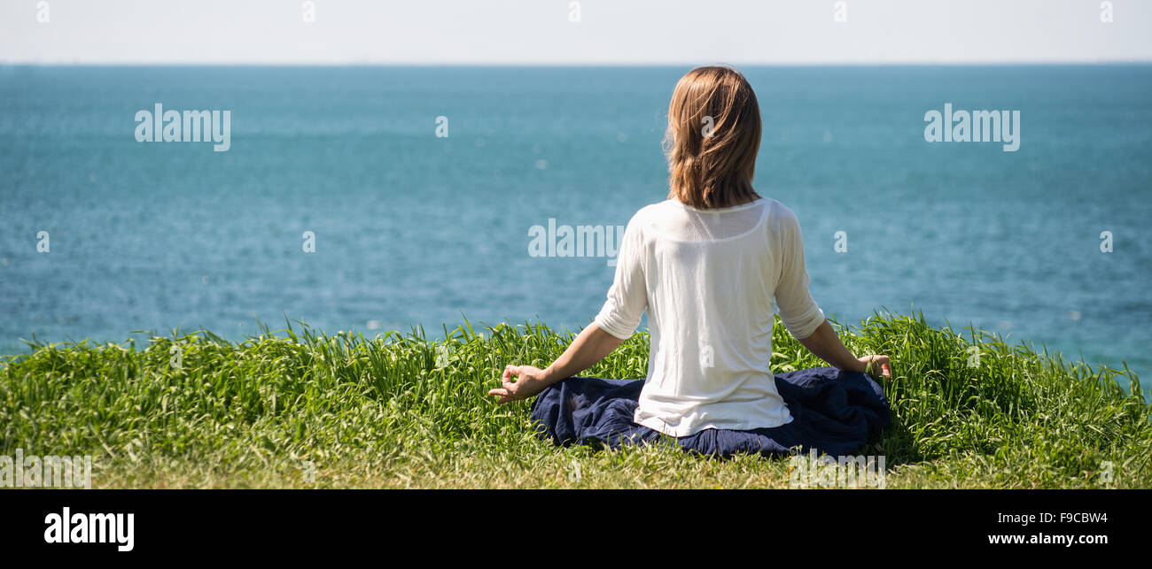 Woman meditating at the sea Stock Photo - Alamy