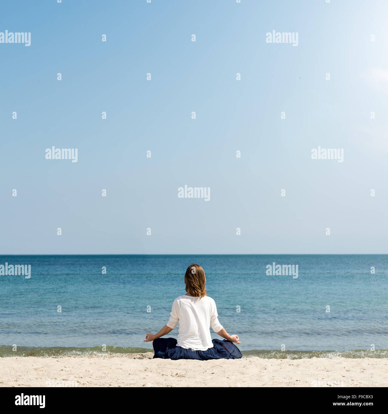 Woman meditating at the sea Stock Photo - Alamy