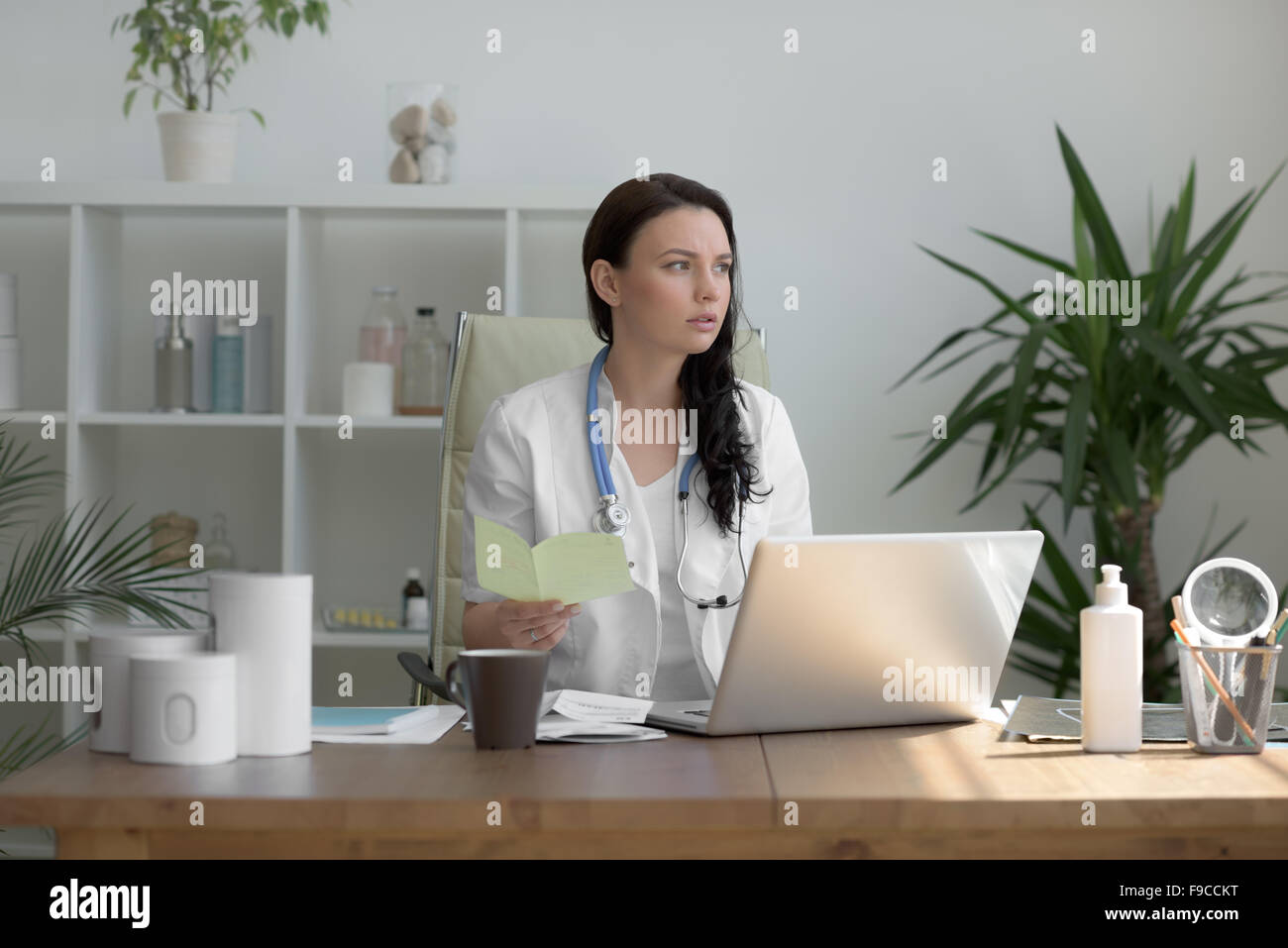 Doctor working with test results and computer at clinic. Filling ...