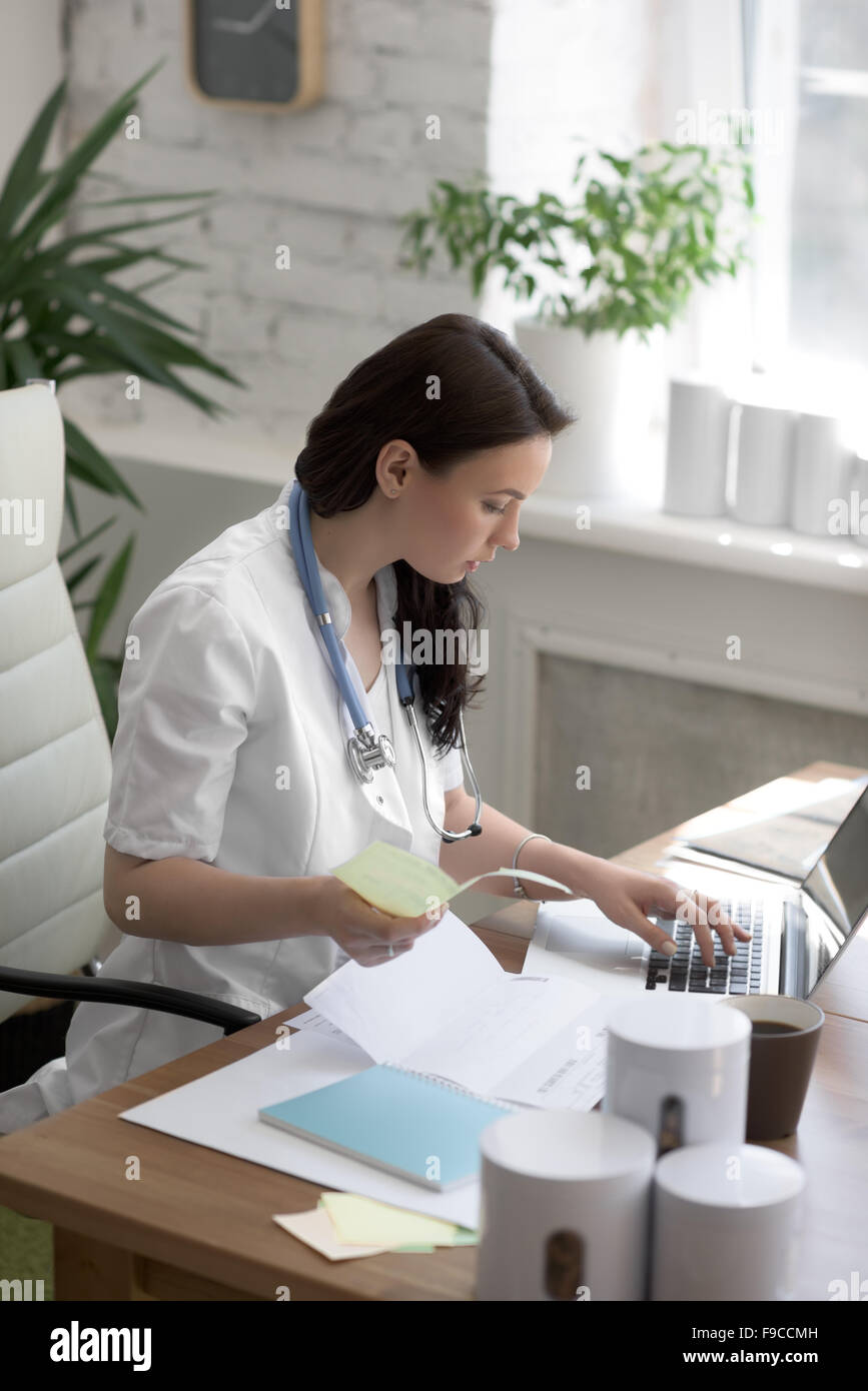 Doctor working with laptop computer at her office Stock Photo - Alamy