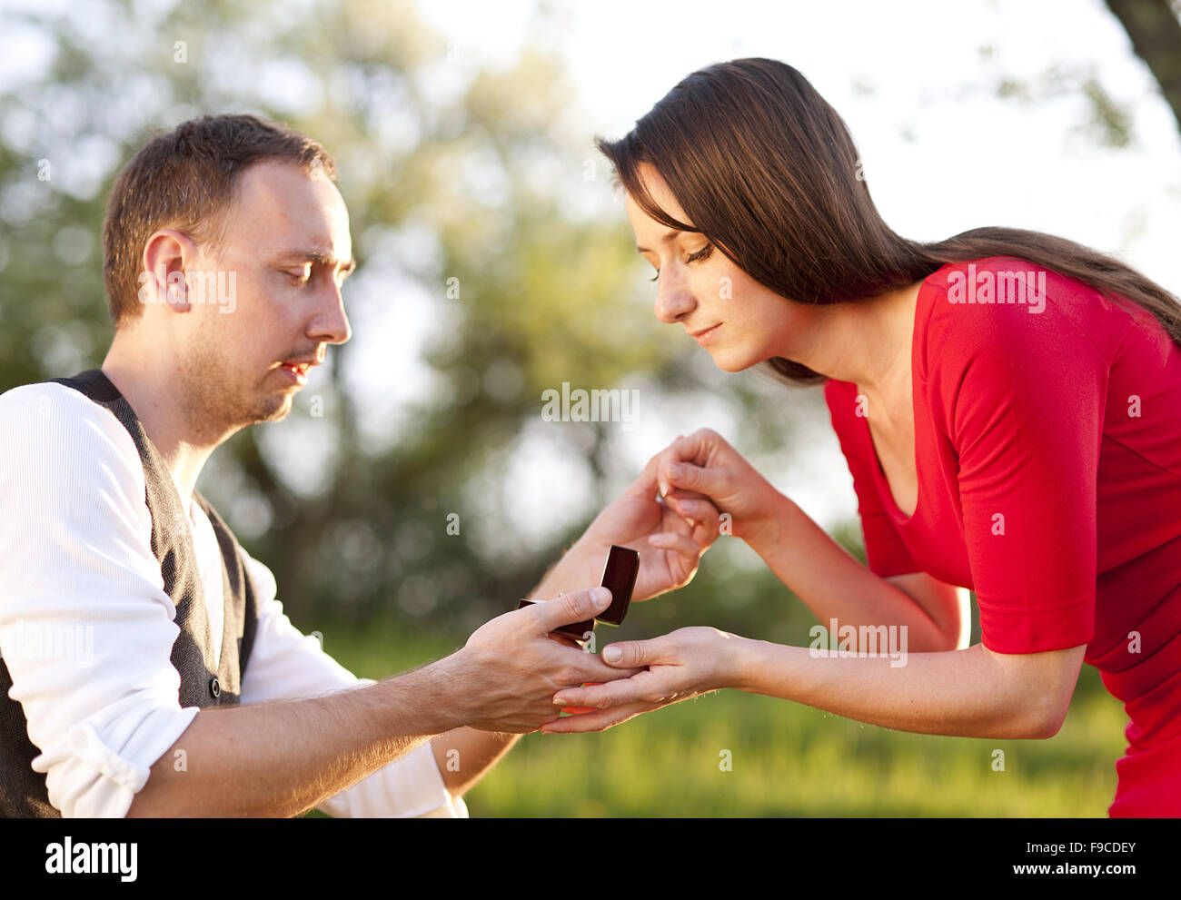 Young man is asking beautiful girl for her hand Stock Photo - Alamy