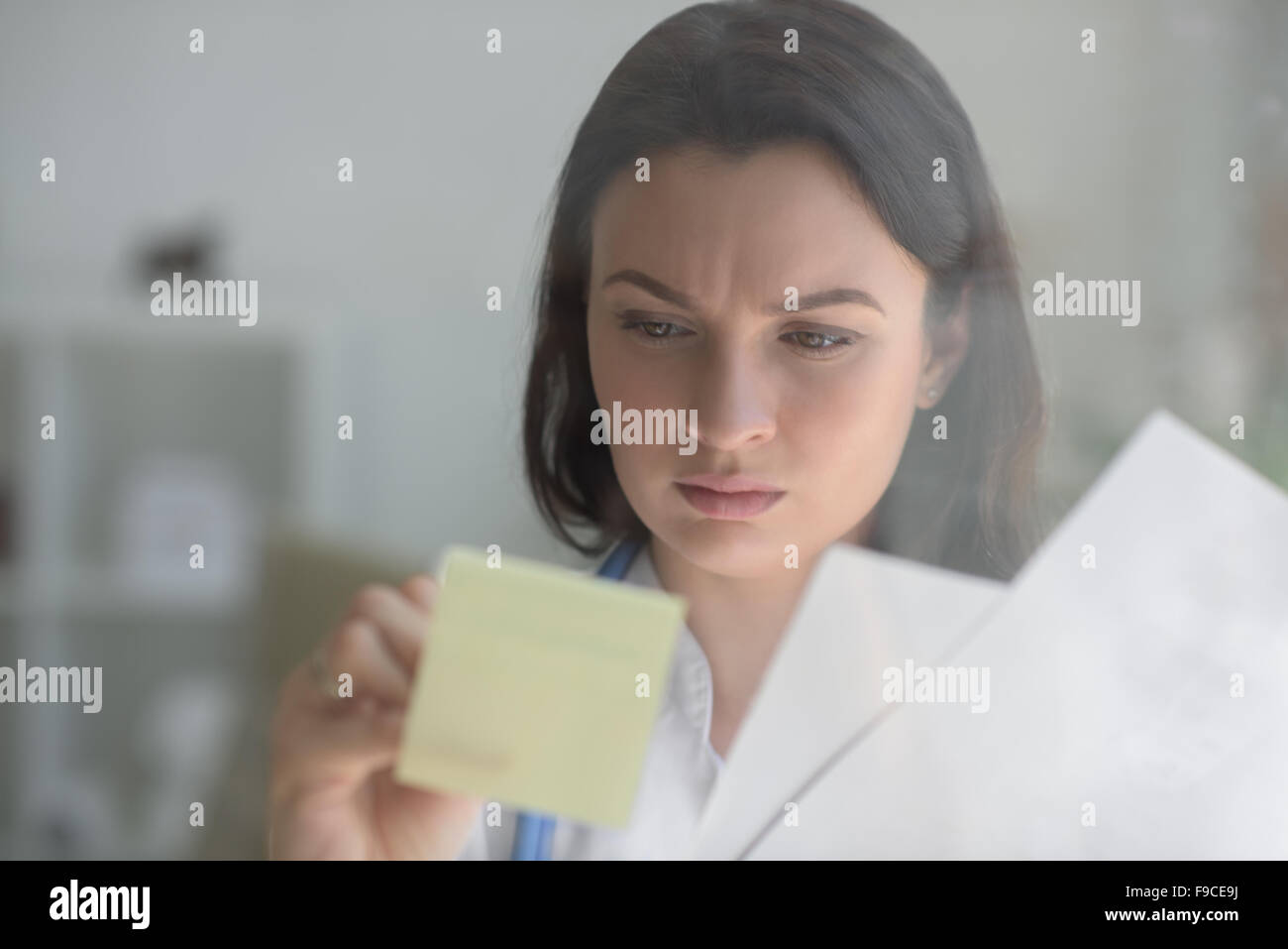 Medical doctor writing patient test results on transparent board to ...