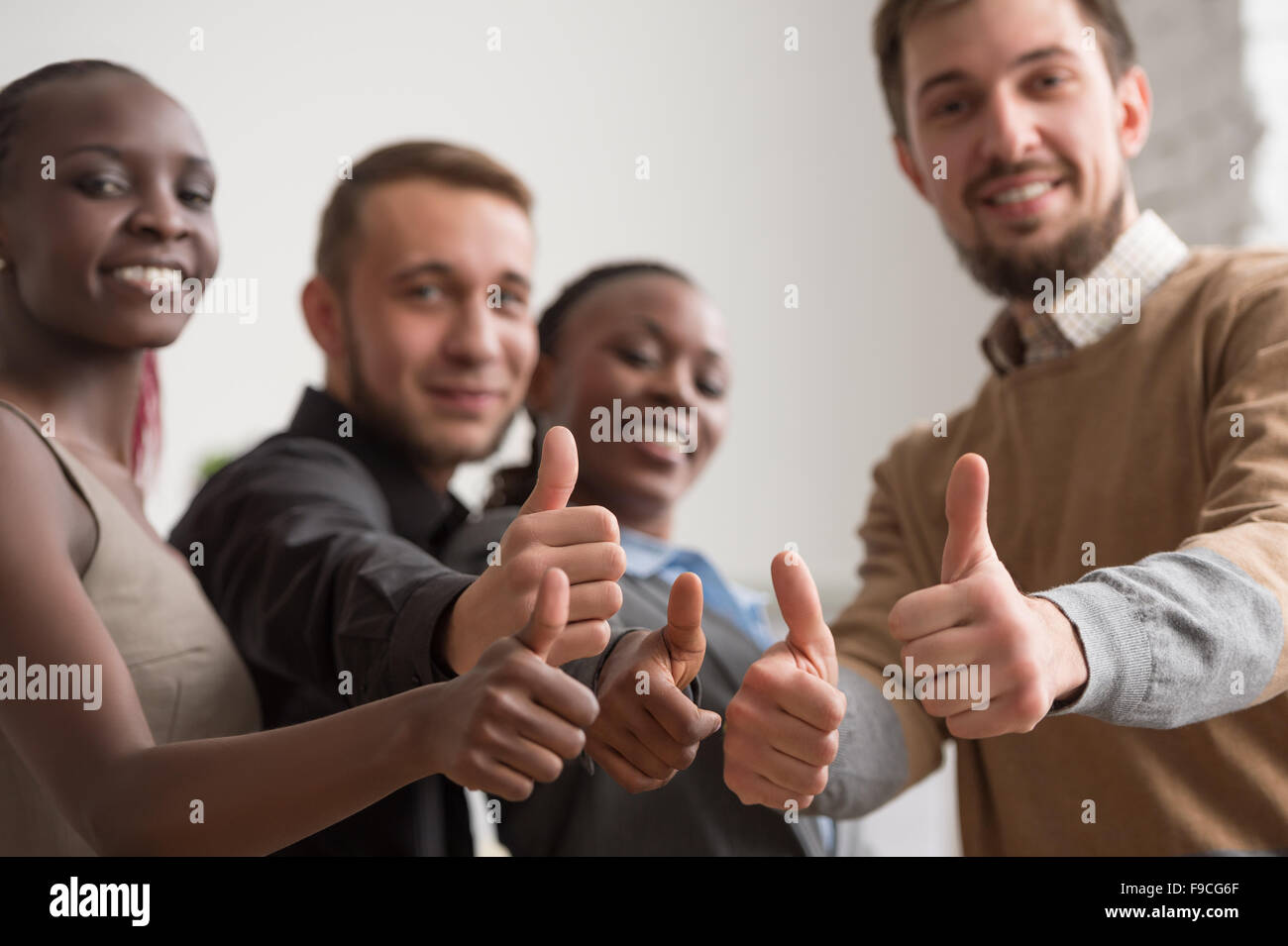 Cheerful business group giving thumbs up Stock Photo - Alamy