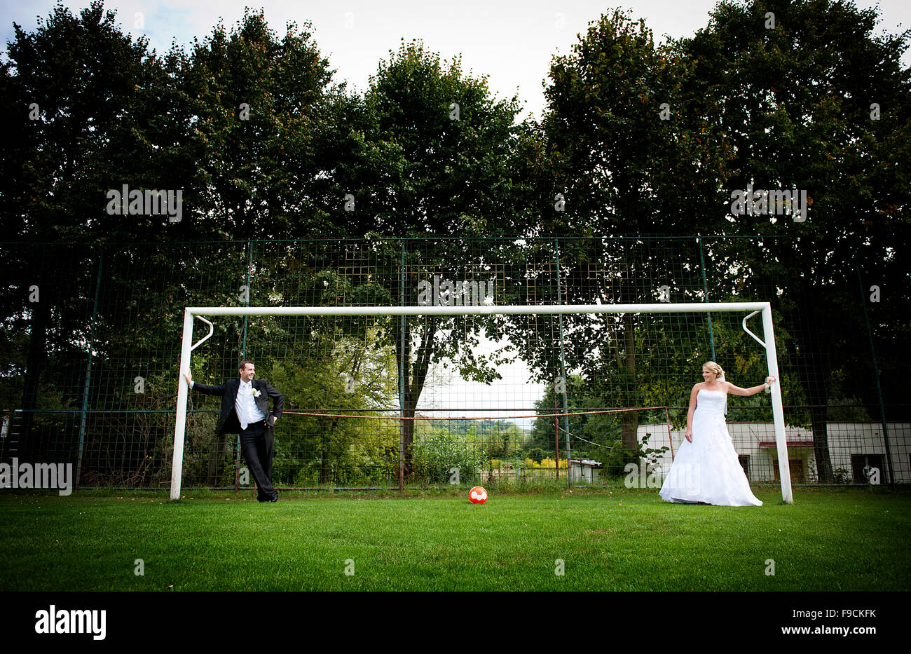 Bride and groom are playing at the football pitch Stock Photo - Alamy
