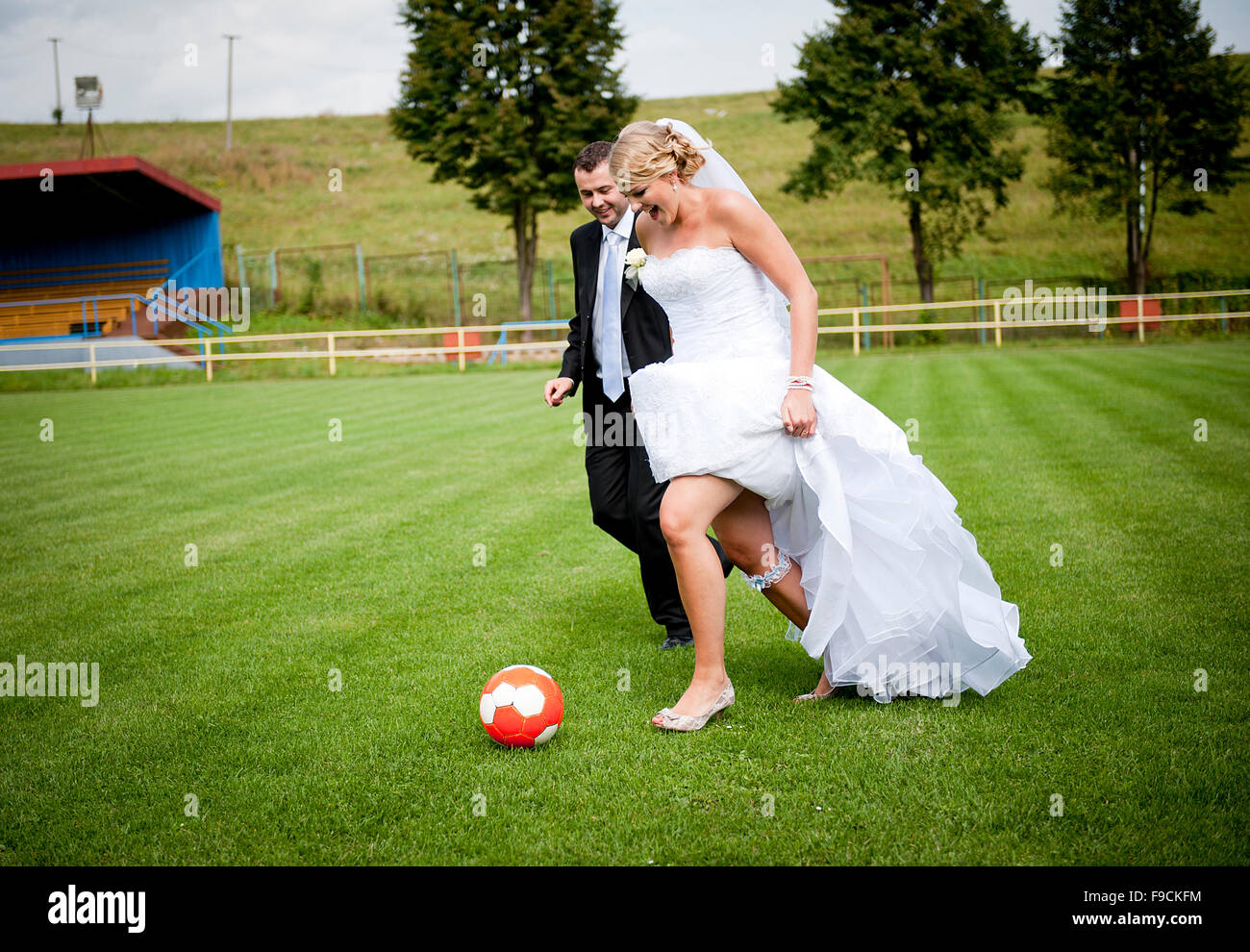 Bride and groom are playing at the football pitch Stock Photo - Alamy