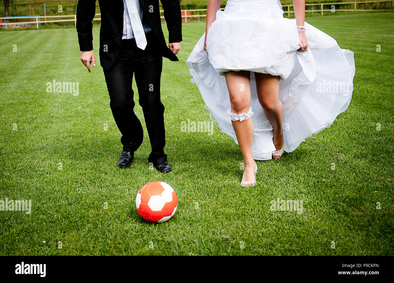 Bride and groom are playing at the football pitch Stock Photo - Alamy