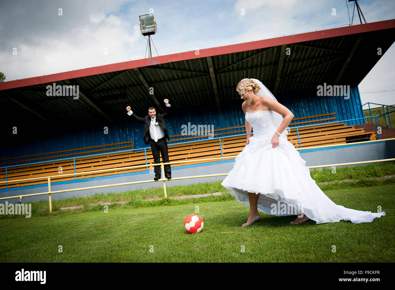 Bride and groom are playing at the football pitch Stock Photo - Alamy