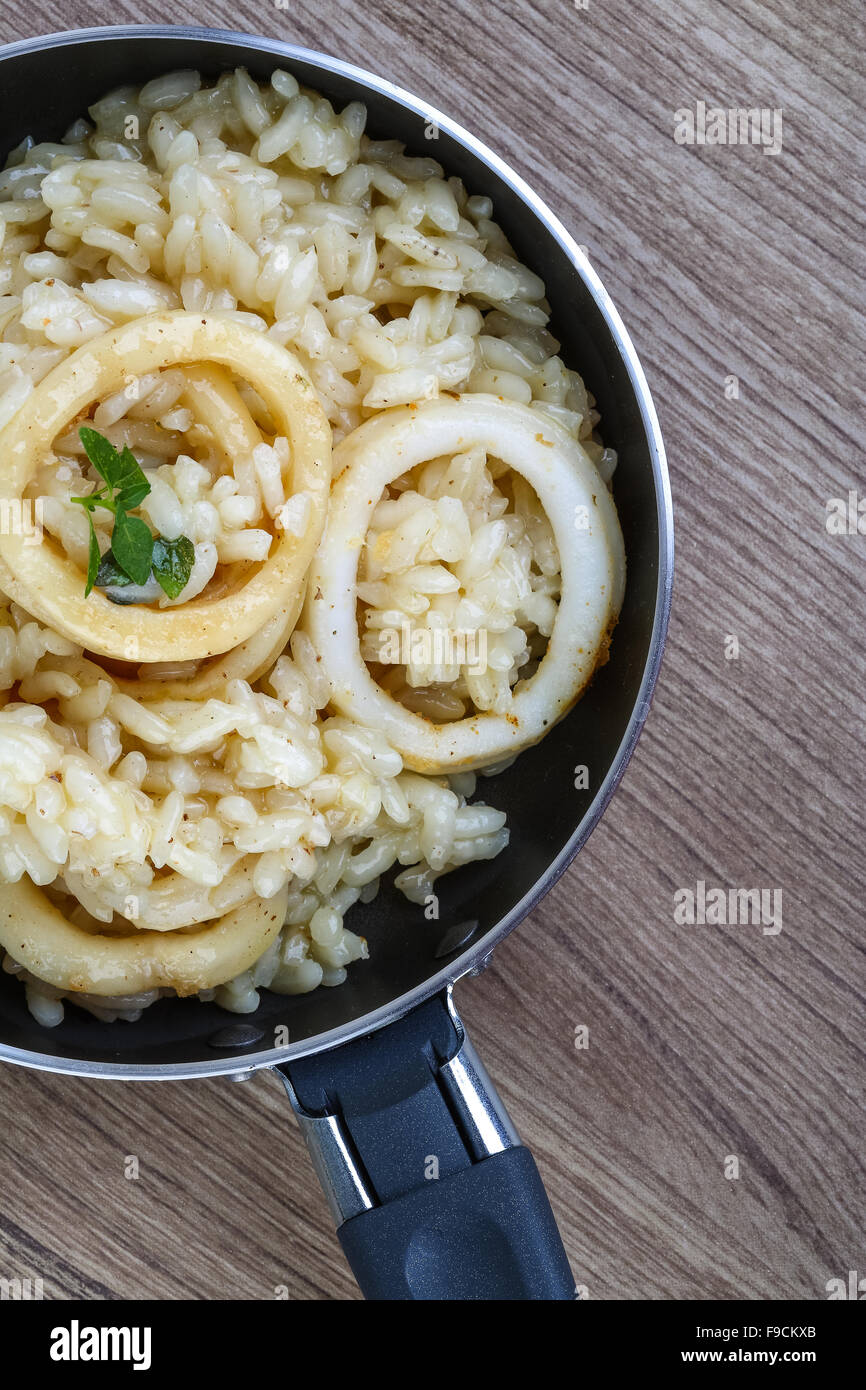 Italian famous cuisine - Squid risotto served basil leaves Stock Photo ...