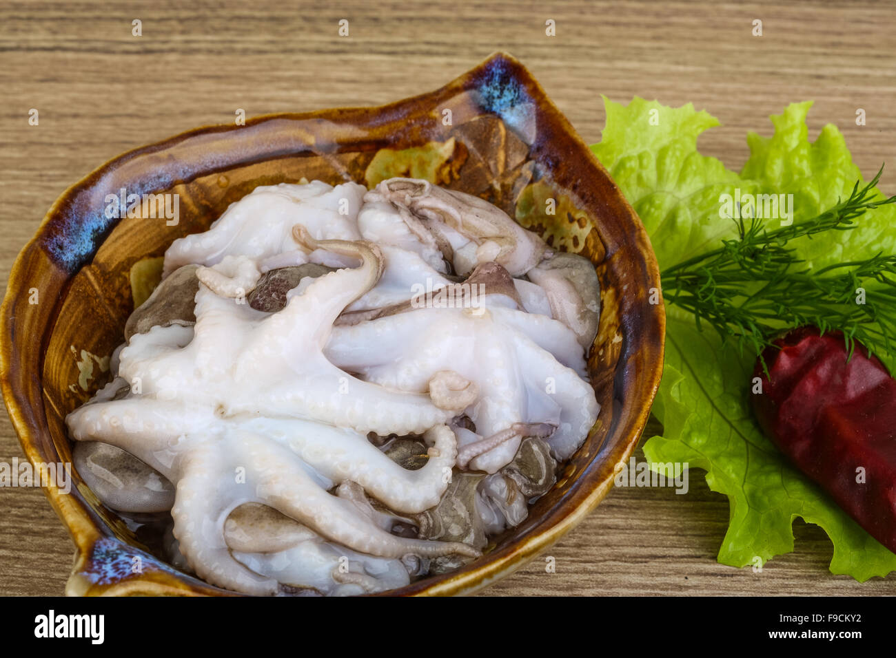 Raw baby octopus in the bowl ready for cooking Stock Photo - Alamy