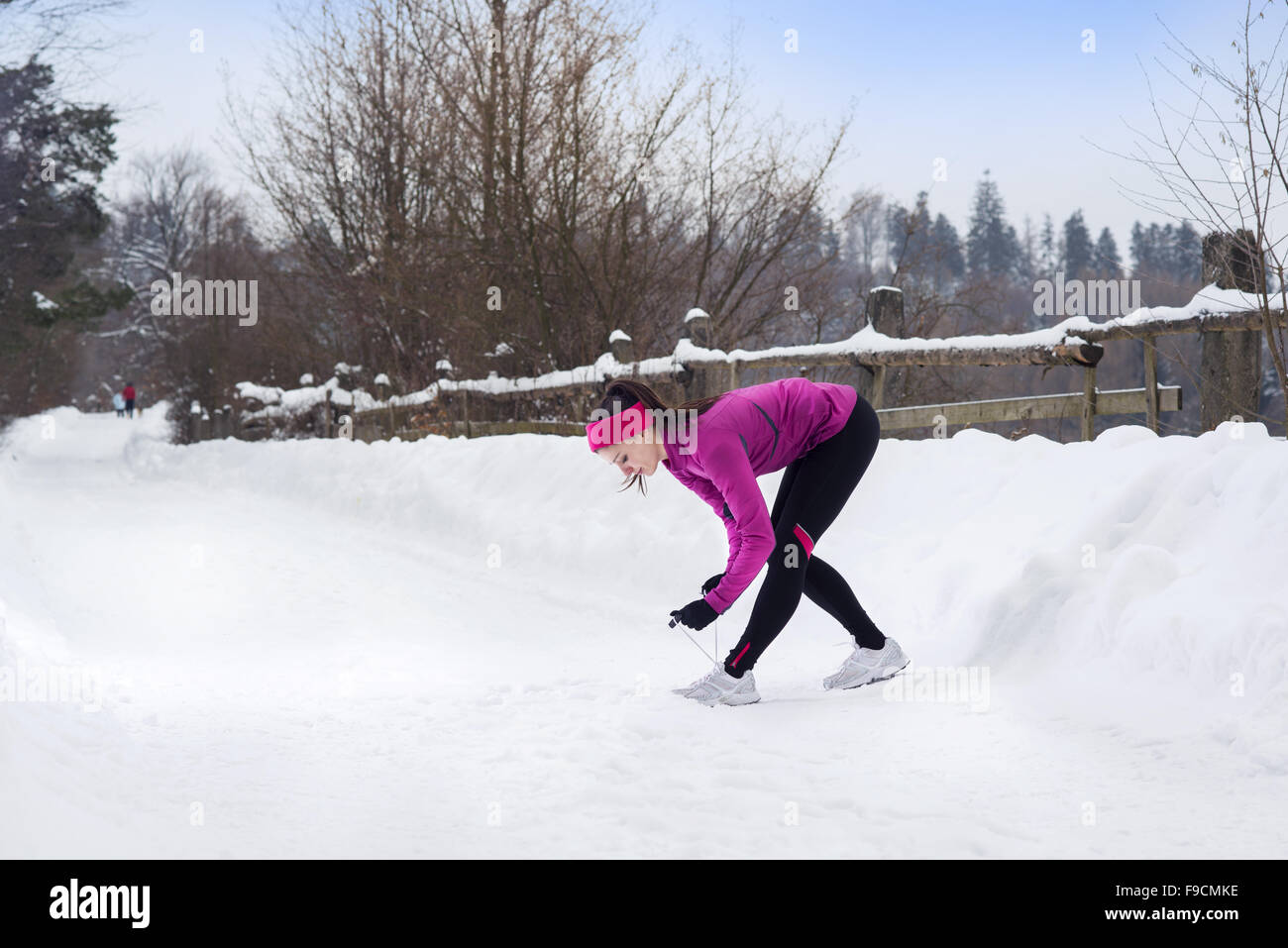 Athlete woman is running during winter training outside in cold snow ...