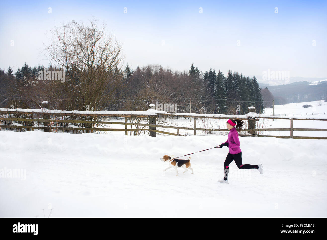 Athlete woman is running during winter training outside in cold snow ...