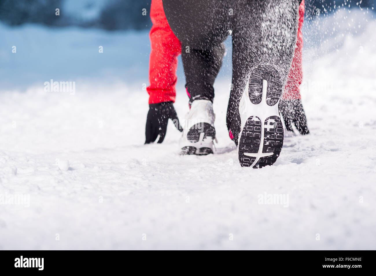 Athlete woman is running during winter training outside in cold snow ...