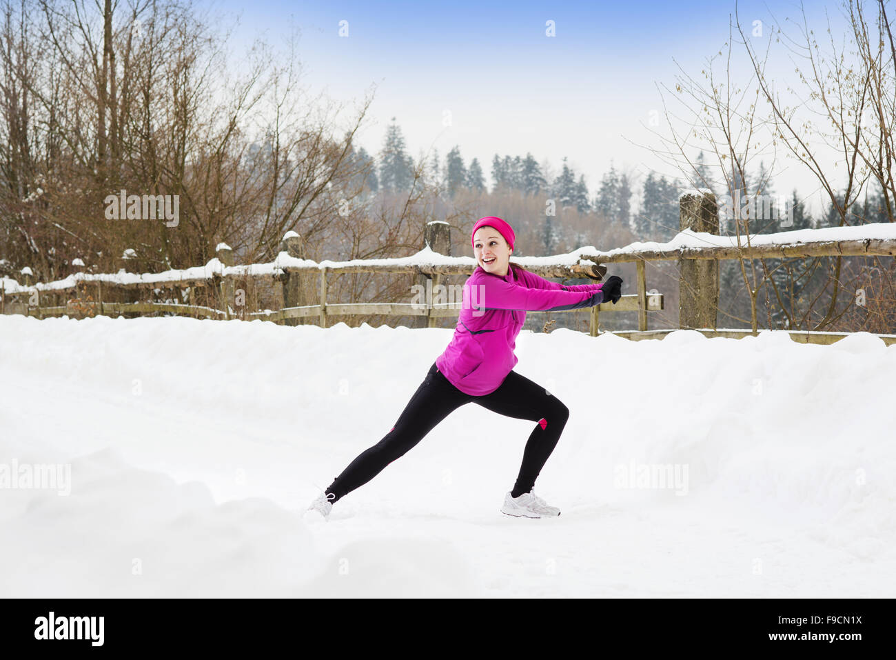 Athlete woman is running during winter training outside in cold snow ...